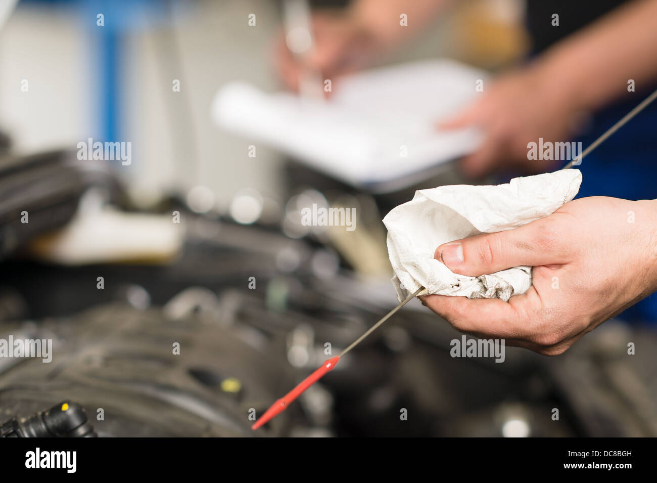 Closeup of the hand of car mechanic checking oil Stock Photo - Alamy