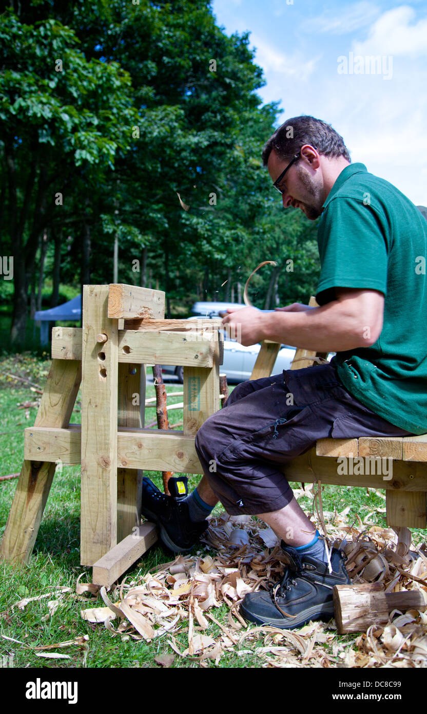 A woodworker / carpenter using a spoke shave and vice / clamp to work a ...