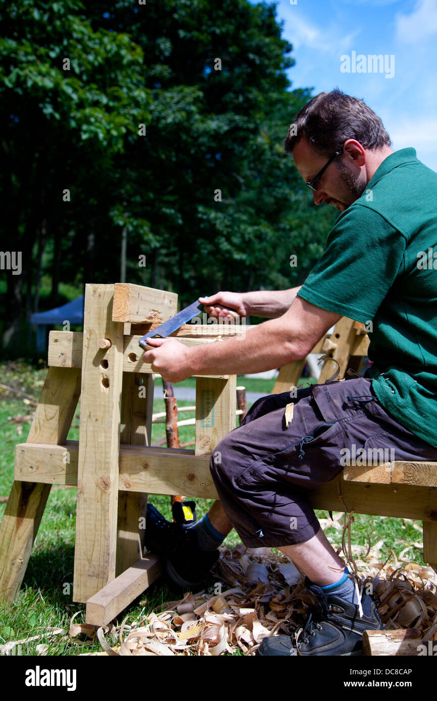 A woodworker / carpenter using a spoke shave and vice / clamp to work a ...