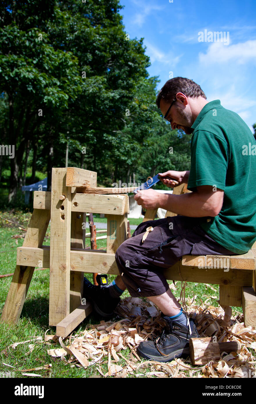 A woodworker / carpenter using a spoke shave and vice / clamp to work a ...