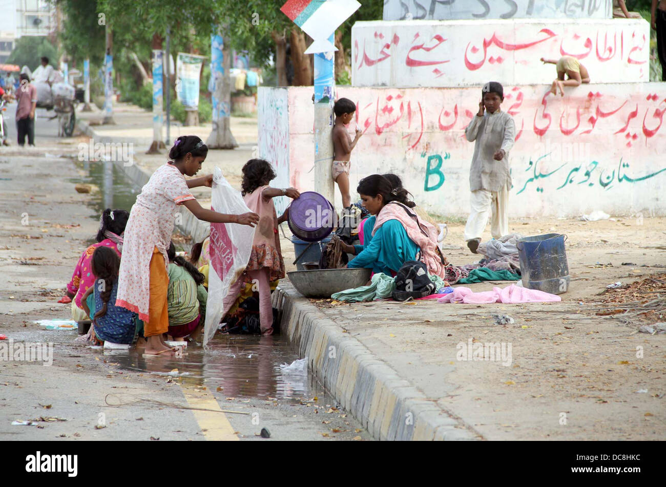 Homeless women washing their clothes with stagnant sewerage water along ...