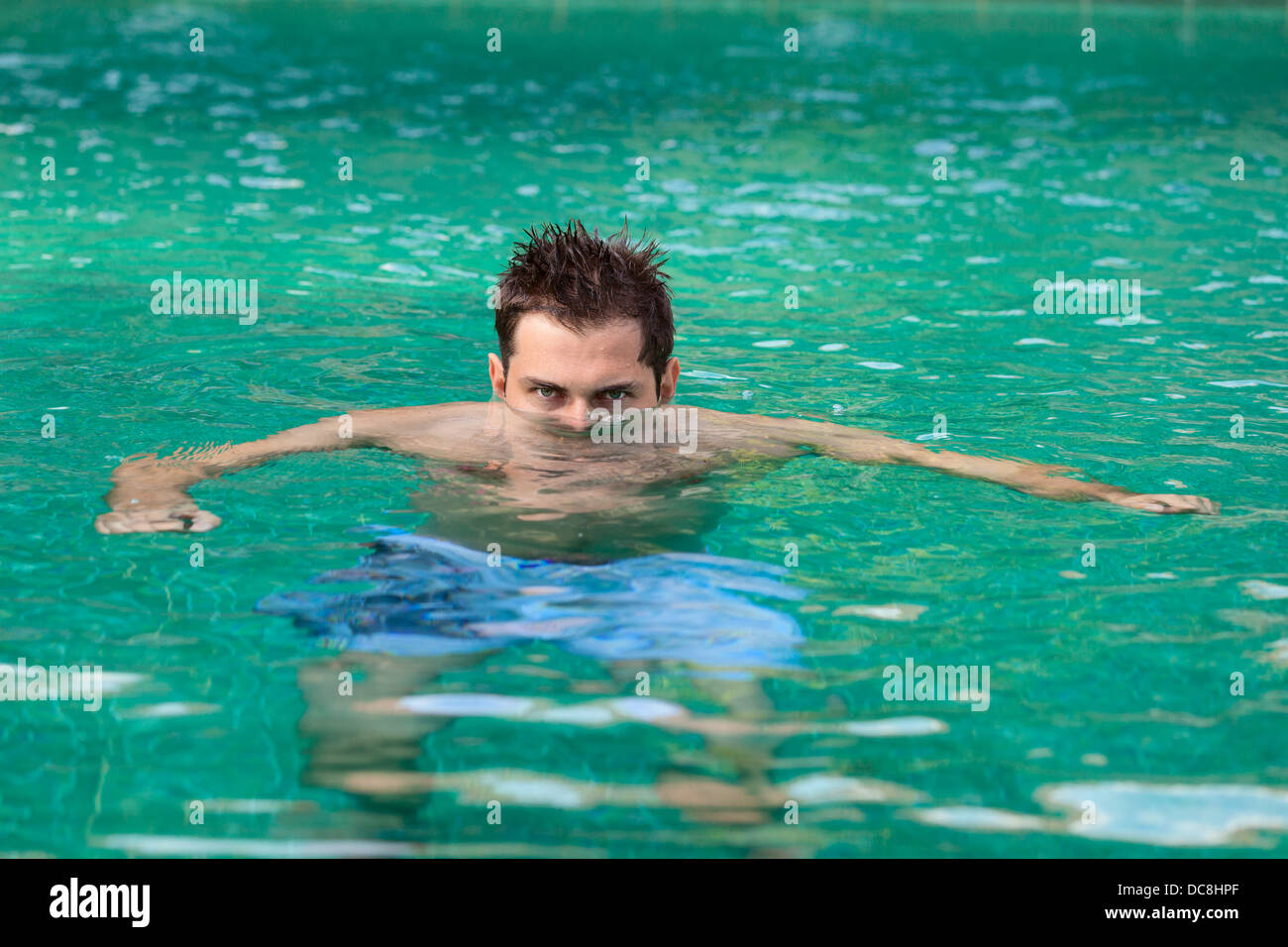 Young serious man looking from water in the swimming pool Stock Photo ...