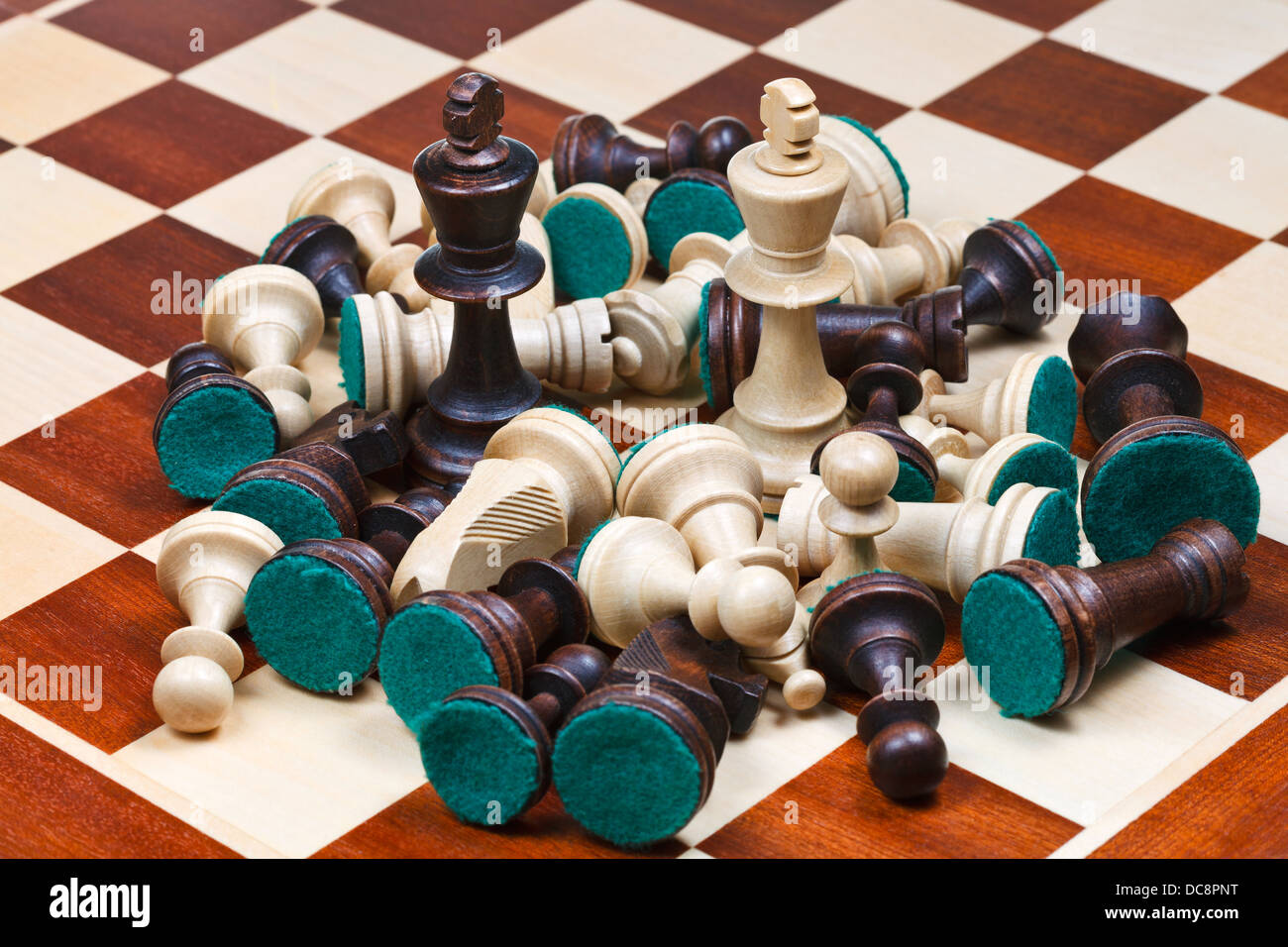 white and black kings in middle of scattered chess pieces on chessboard ...