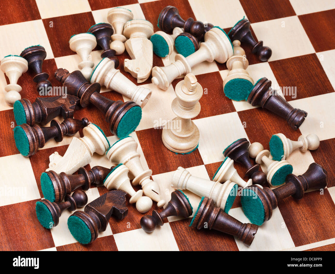 lonely white king and scattered chess pieces on chessboard Stock Photo ...