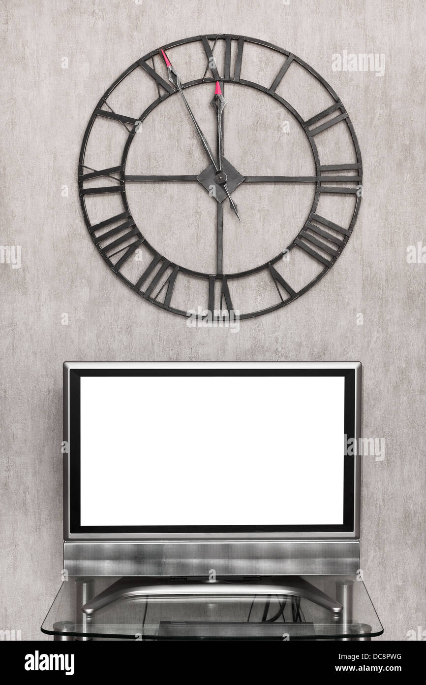 five minutes to midnight on wall clock under blank white screen of TV ...