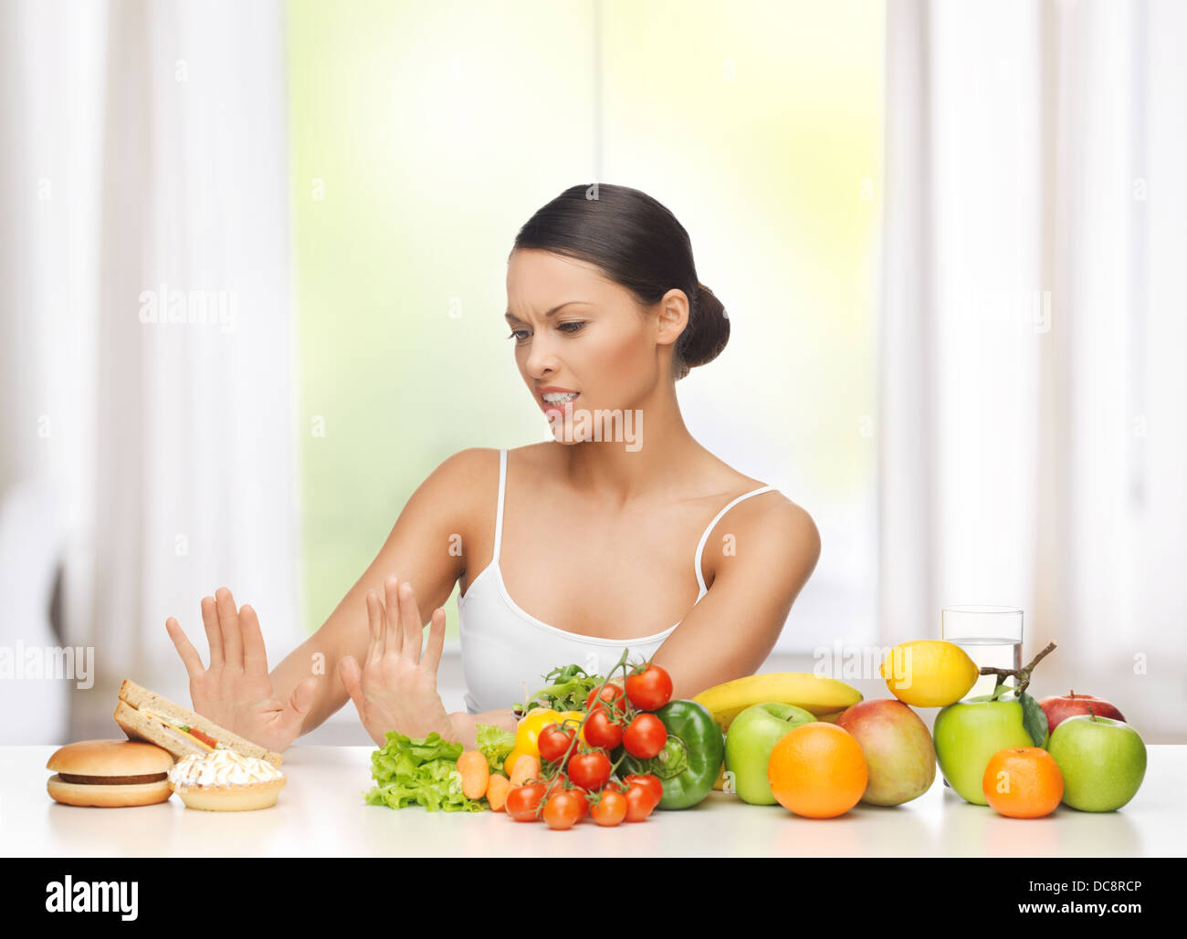 woman with fruits rejecting junk food Stock Photo - Alamy
