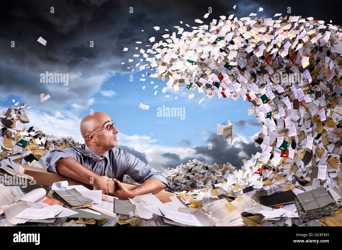 Castaway businessman in a sea of papers and files Stock Photo - Alamy