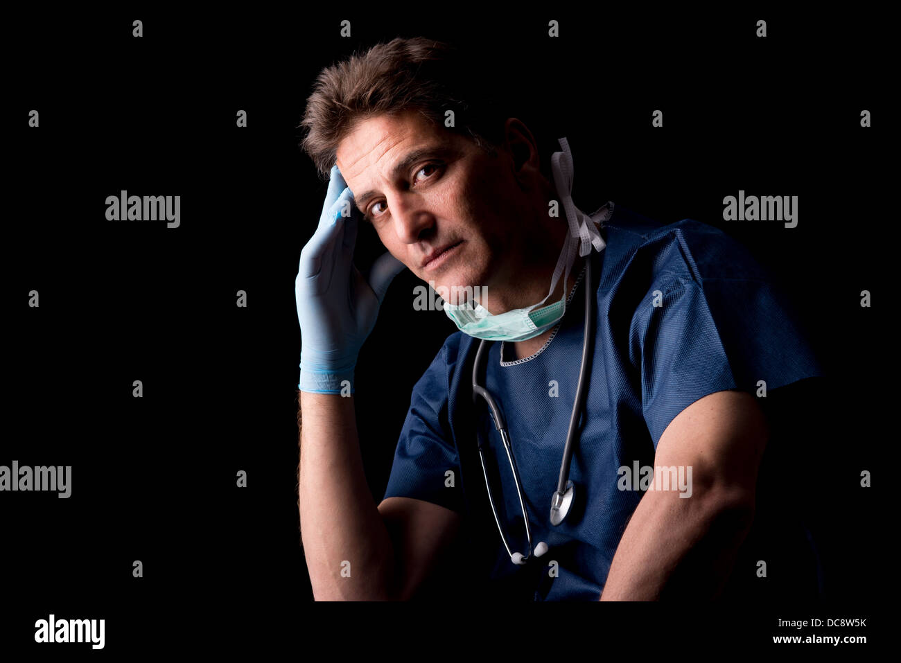 Tired doctor in uniform isolated against a black background Stock Photo ...