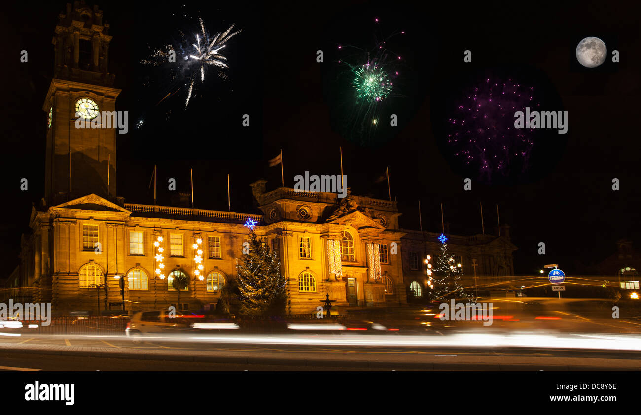 Fireworks and a full moon in the night sky over an illuminated building ...