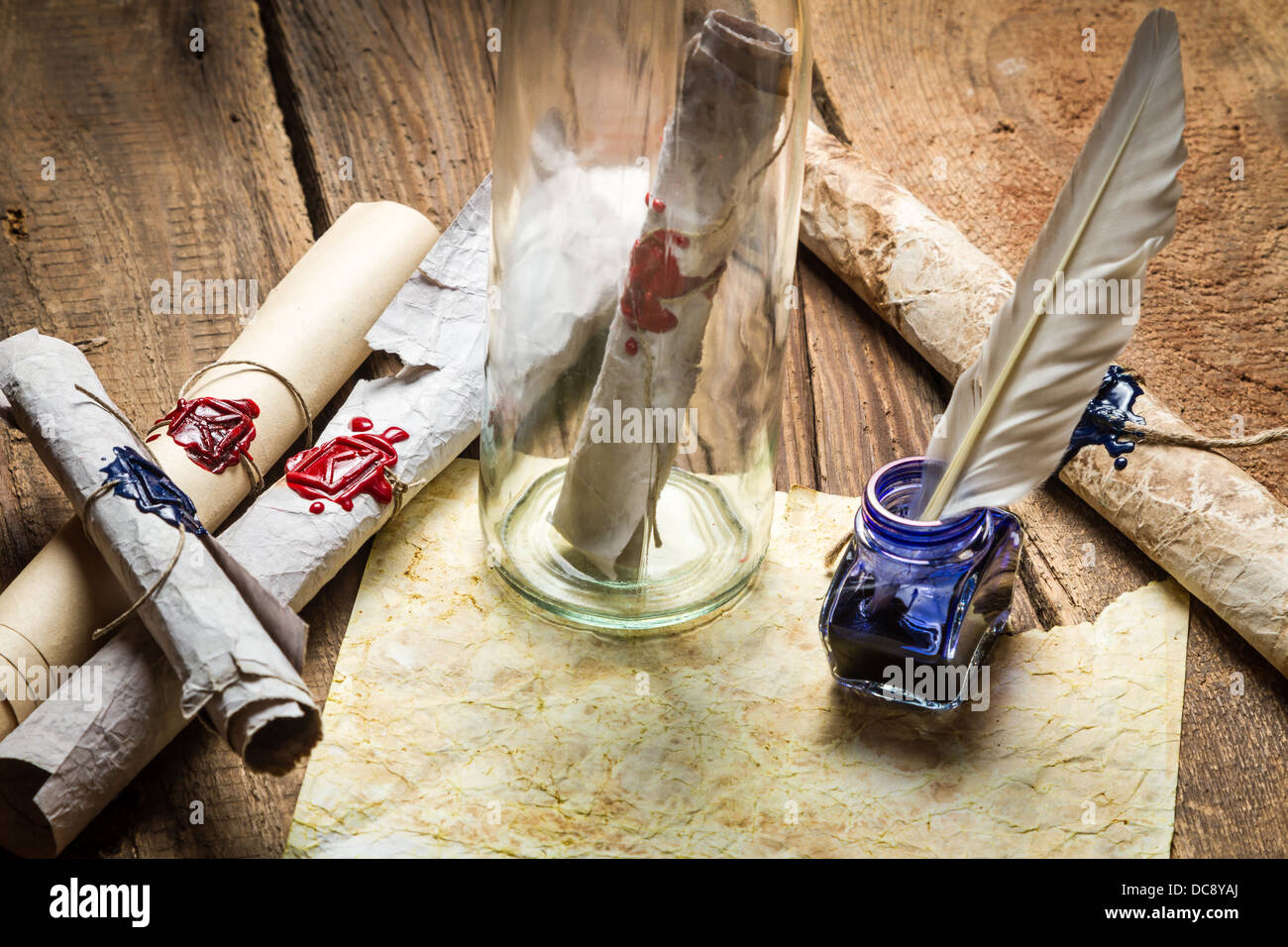 Preparing to send ancient letter in a bottle and writting with blue ink ...
