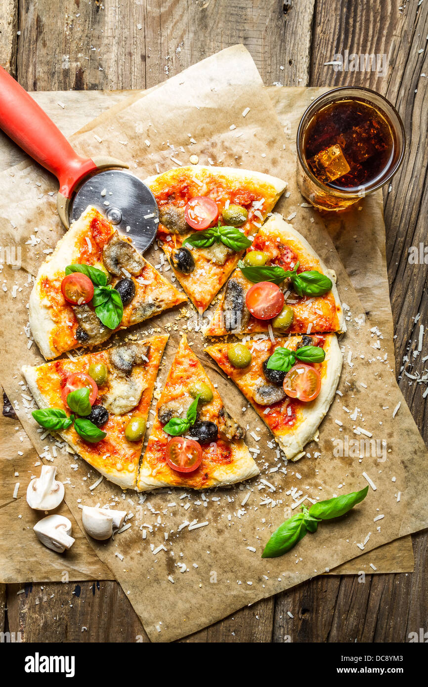 Cutting homemade pizza with basil Stock Photo - Alamy