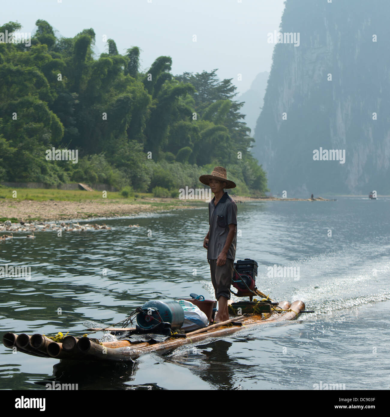 A man riding a motorized raft down the River Li; Guilin, Guangxi, China ...