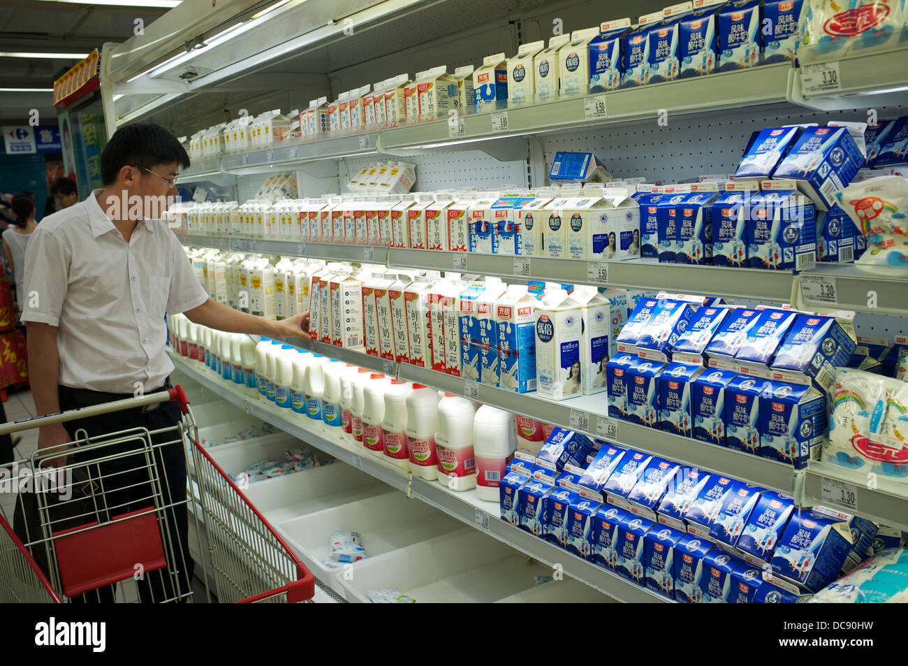 A man buying milk products in a Carrefour supermarket in Beijing, China ...