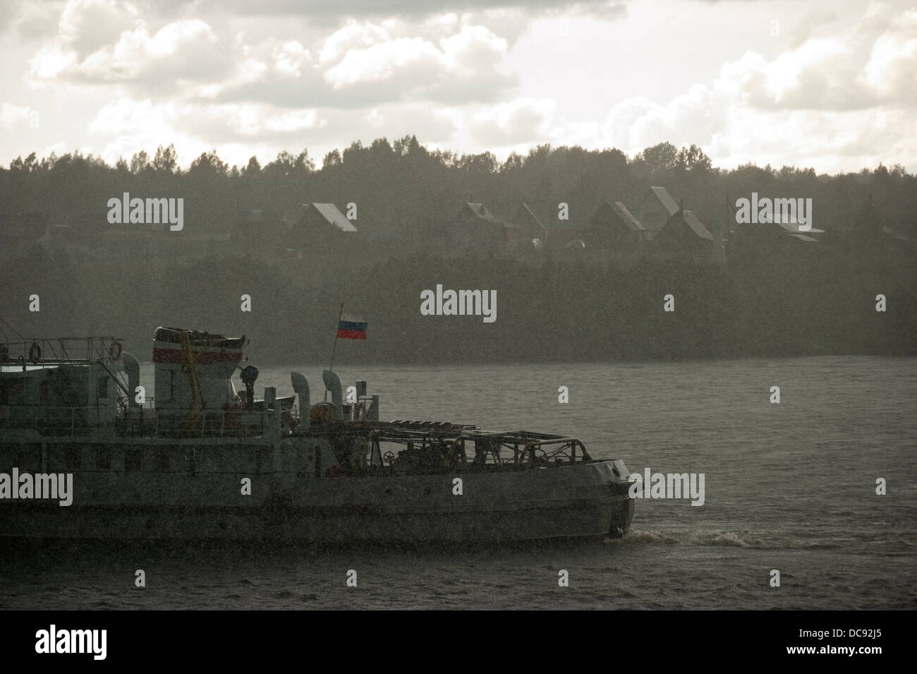 Cargo ship and scenic view of a village under rain Volga-Baltic ...