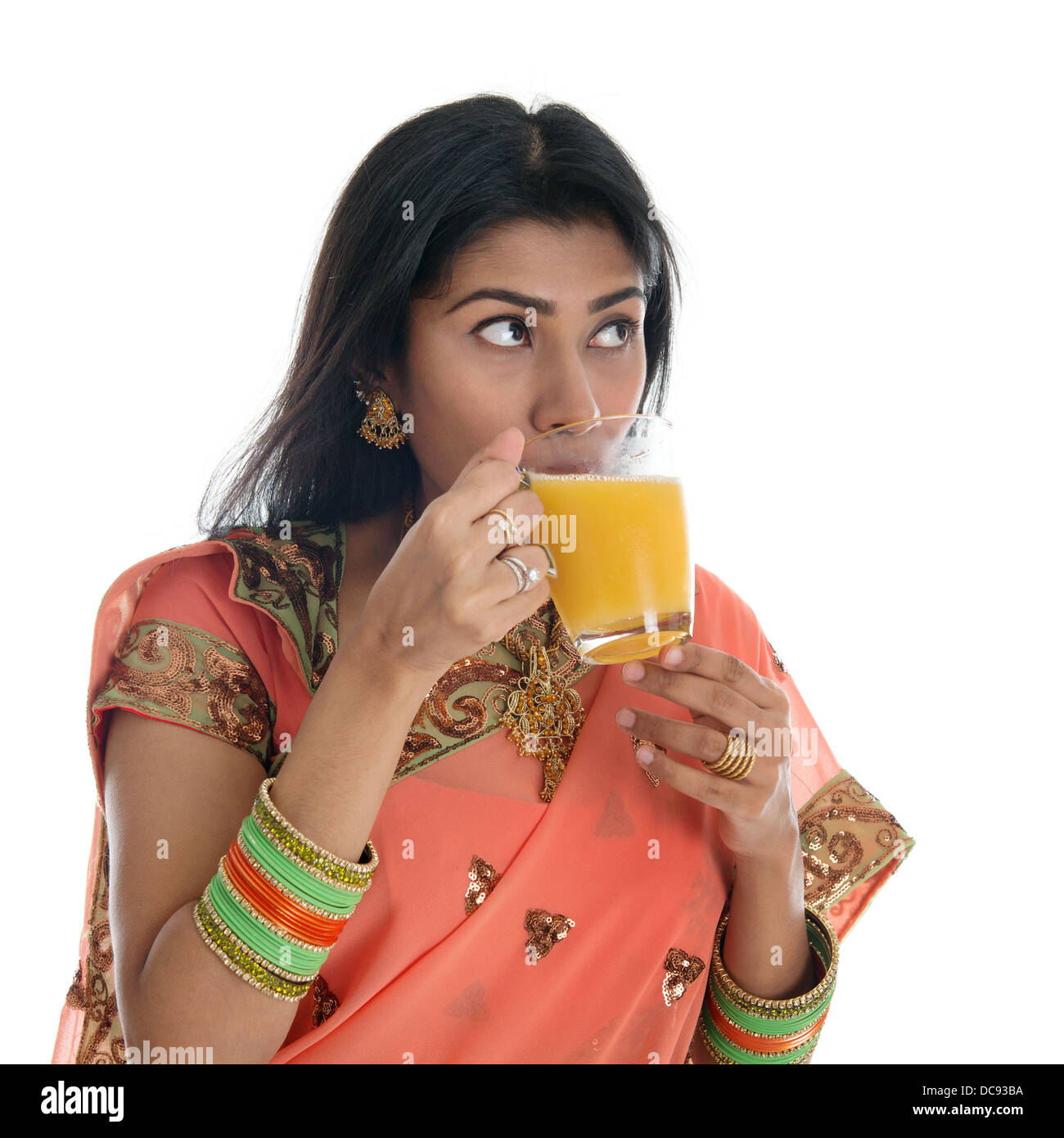 Traditional Indian woman in sari drinking orange juice, isolated on ...
