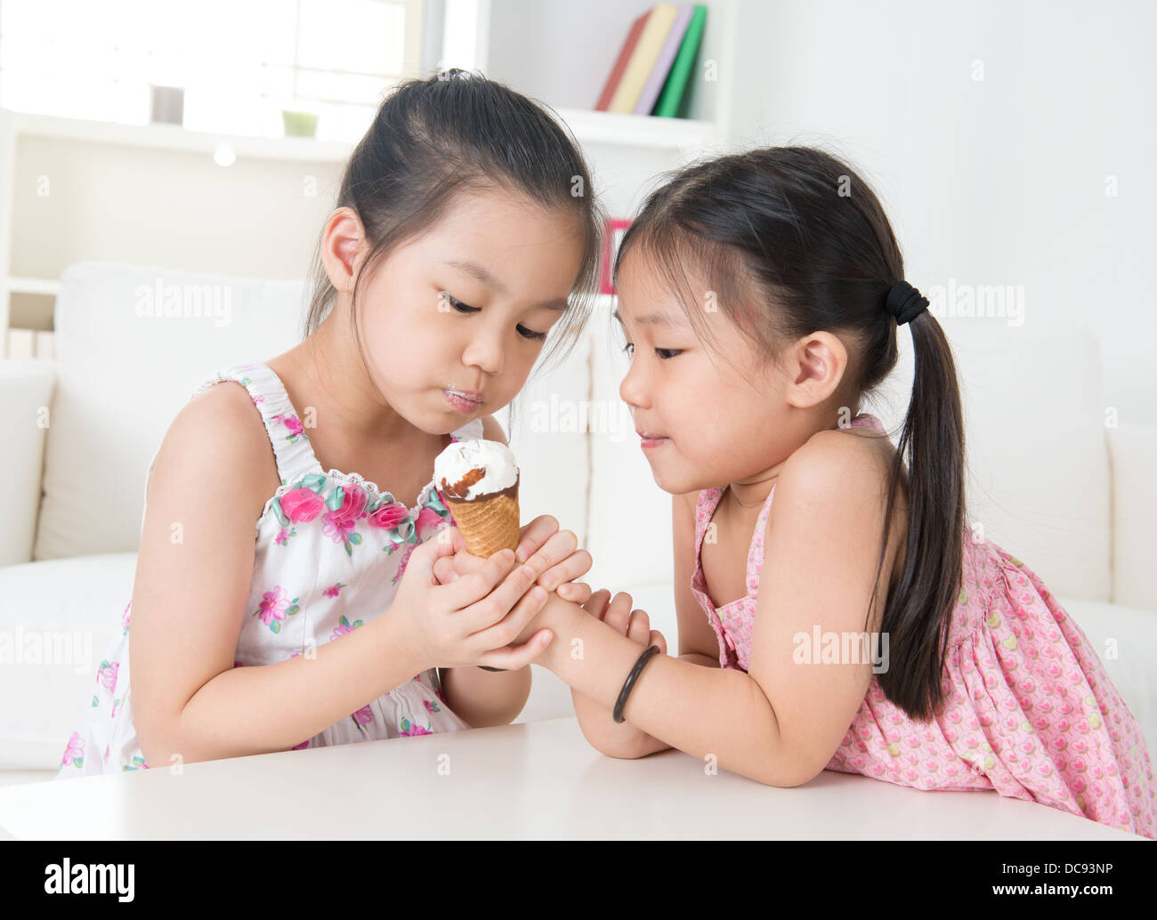 Eating ice cream cone. Asian children sharing an ice cream. Beautiful ...