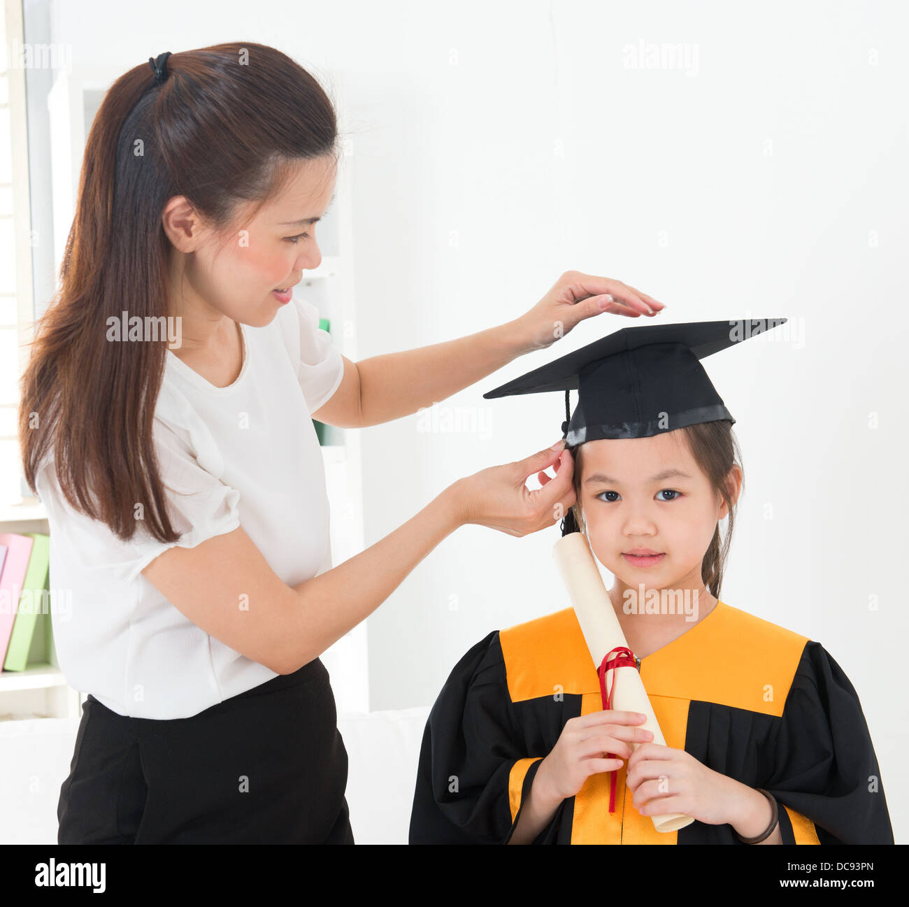 Asian child graduation, teacher adjusting cap for student indoor Stock ...