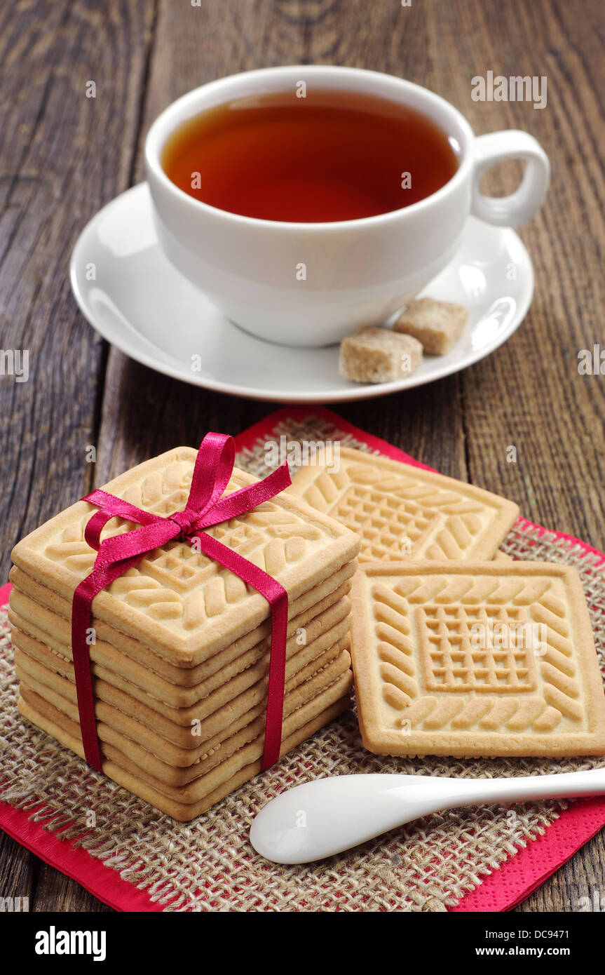 Cookies tied red ribbon and cup of tea on table Stock Photo - Alamy