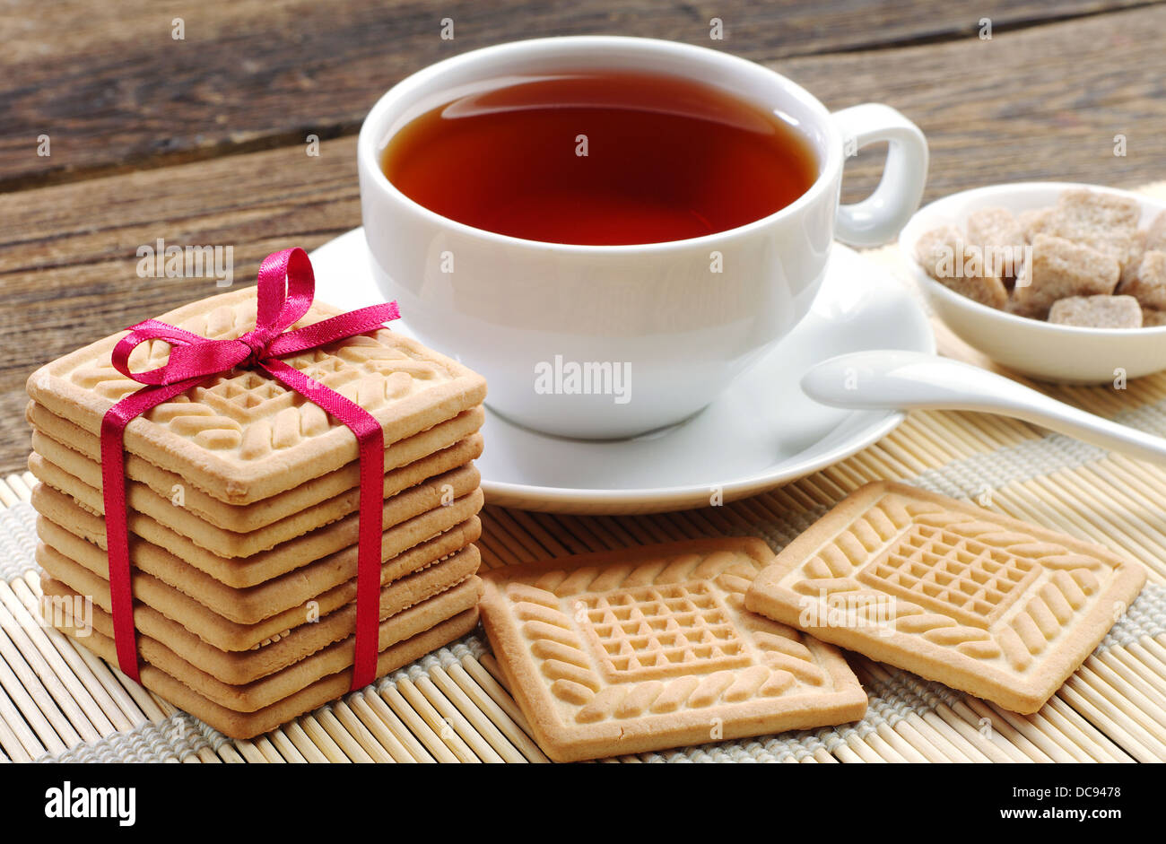 Cookies tied red ribbon and cup of tea on wooden table Stock Photo - Alamy