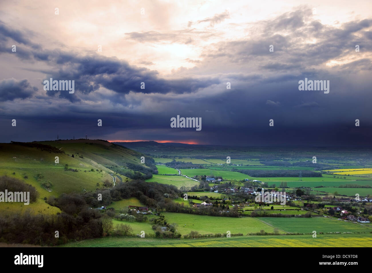 Dark moody skies form over bright fresh Spring countryside landscape ...