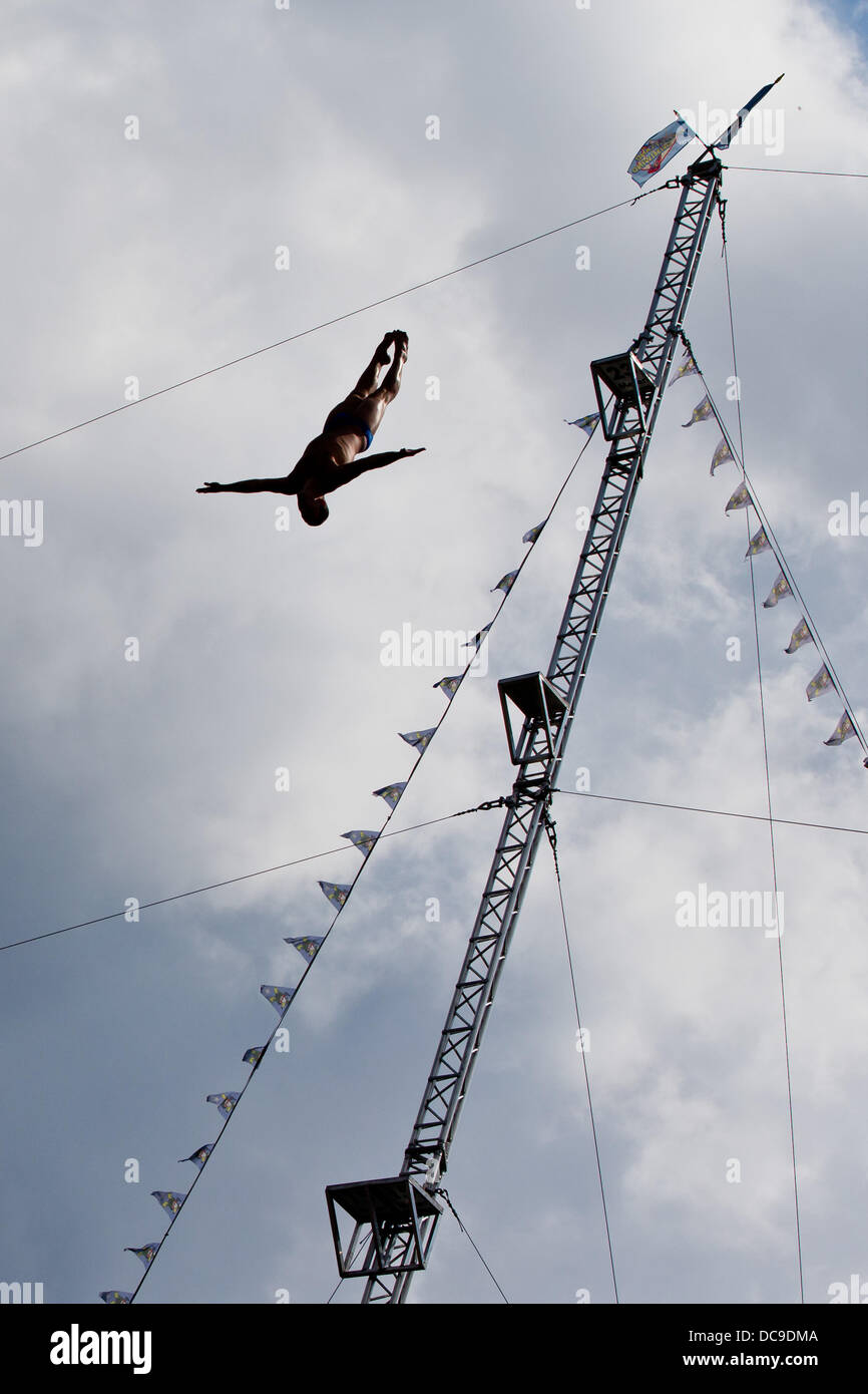 An acrobat jumps into a pool at an amusement park in Geiselwind ...