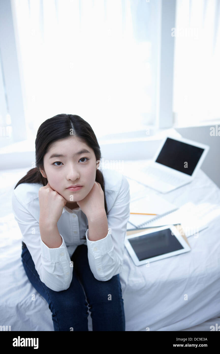 a student sitting on a bed thinking Stock Photo - Alamy