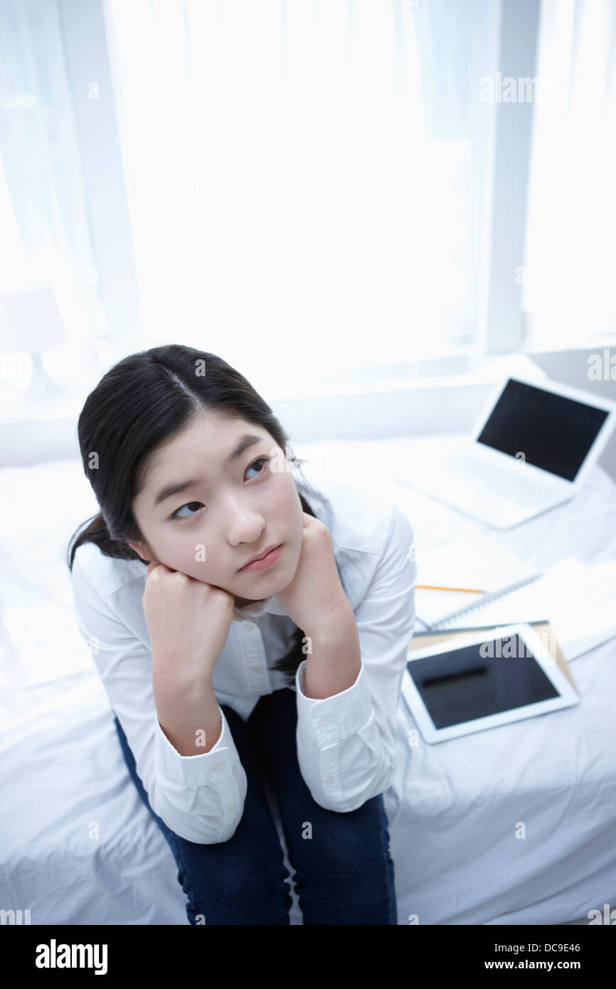 a student sitting on a bed thinking Stock Photo - Alamy