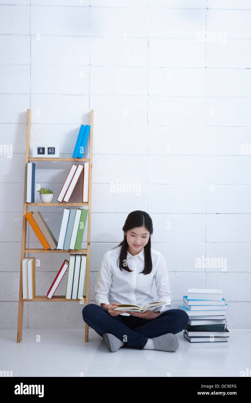 a student reading a book while sitting on the floor Stock Photo - Alamy