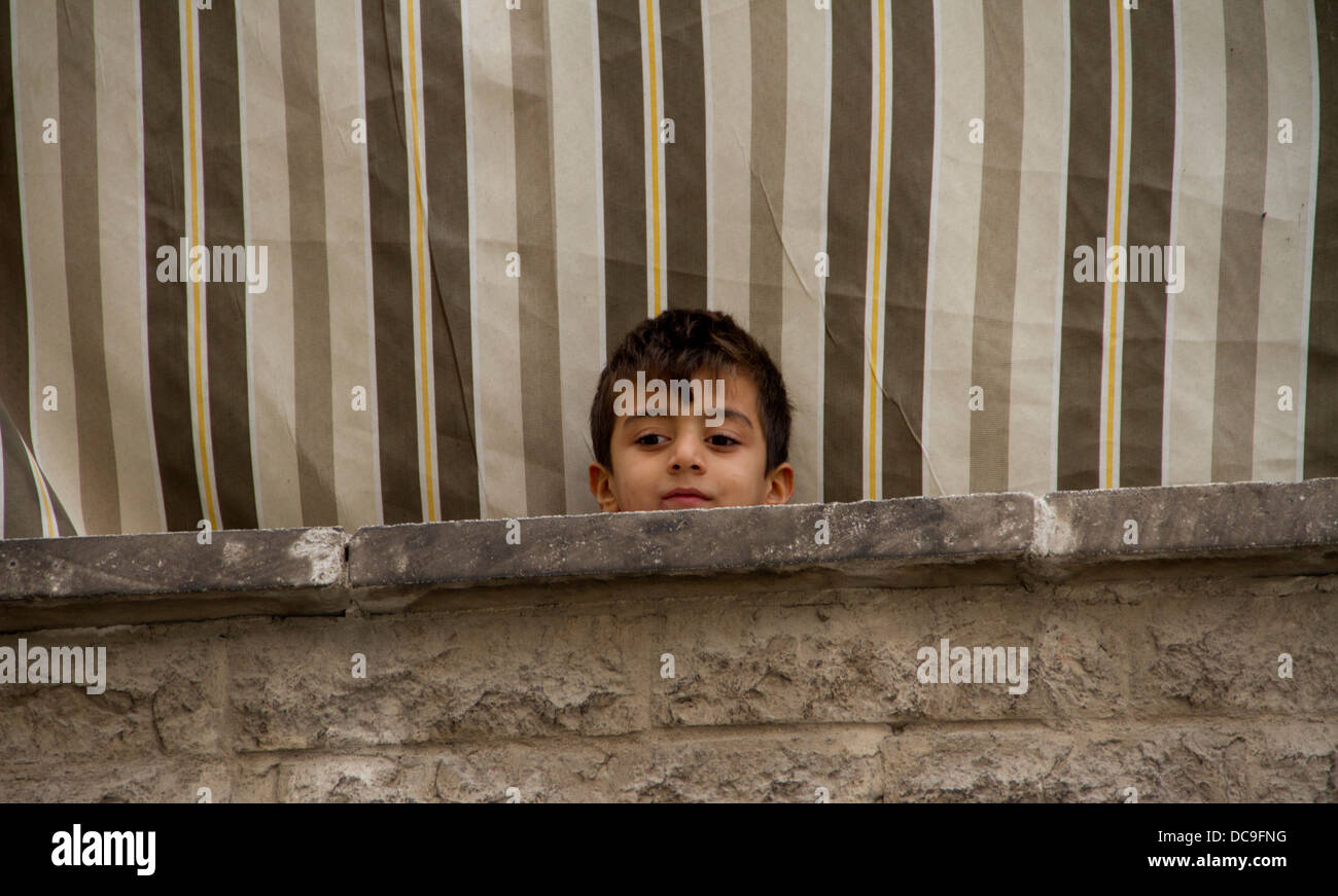 A boy looks off a balcony in Aleppo Stock Photo - Alamy