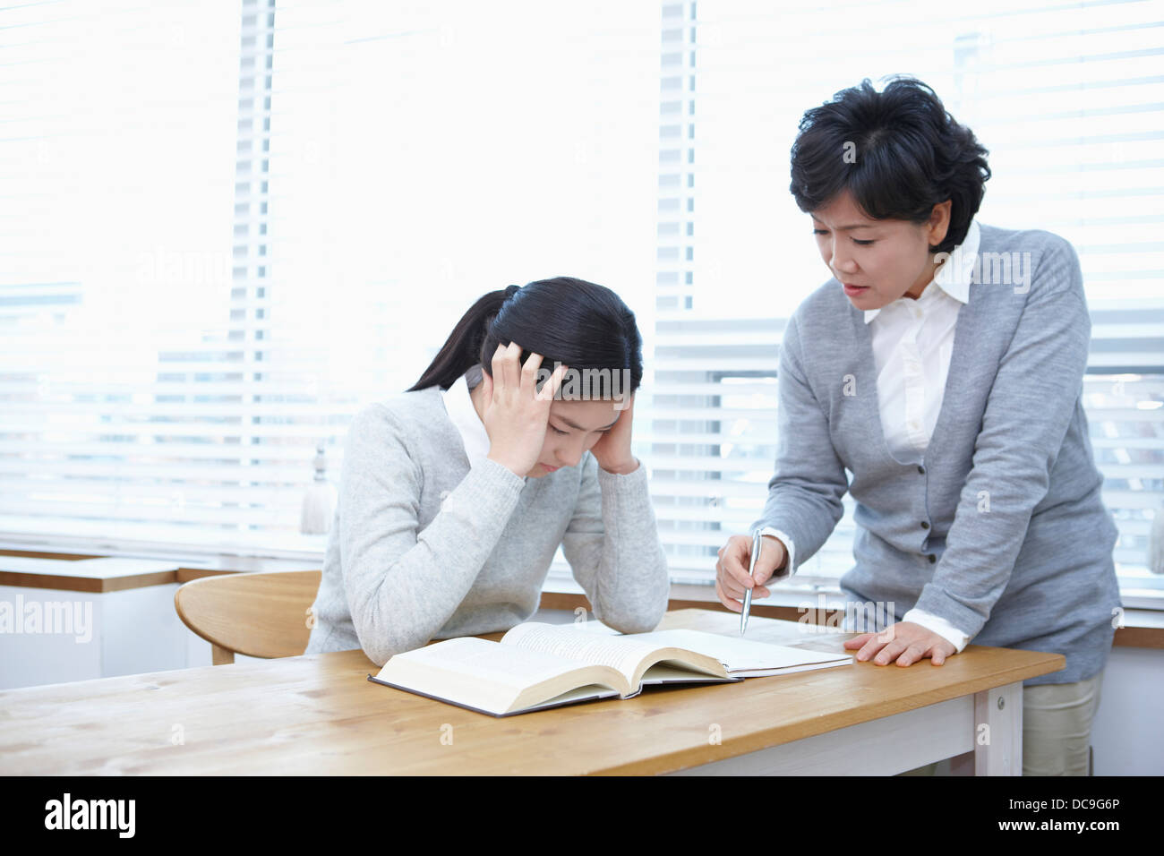 middle aged woman teaching a student Stock Photo - Alamy