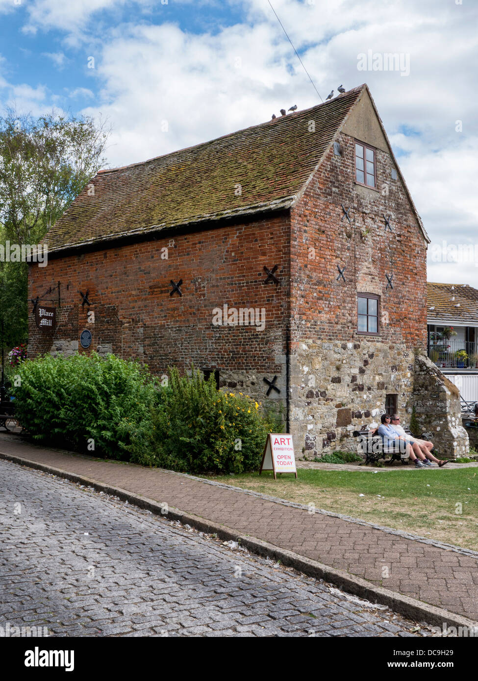 Two people sitting on bench at the Grade ll listed Anglo-Saxon water ...