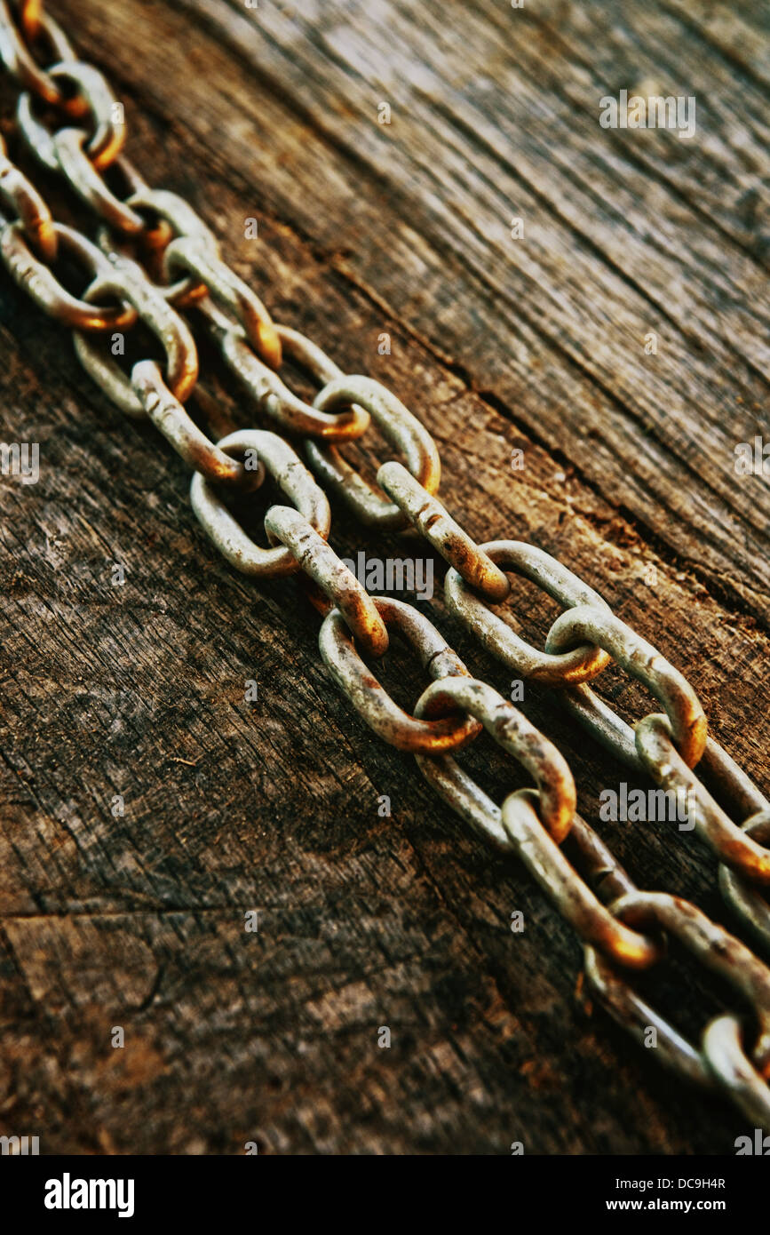 Rusty chain on weathered wood background Stock Photo - Alamy