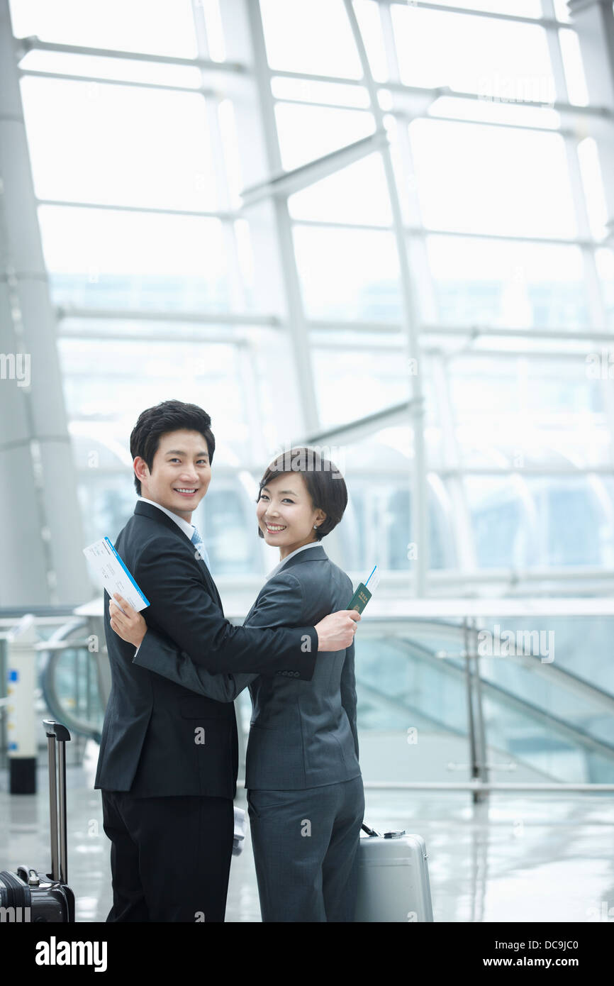 a businesswoman and businessman hugging each other in the airport Stock ...
