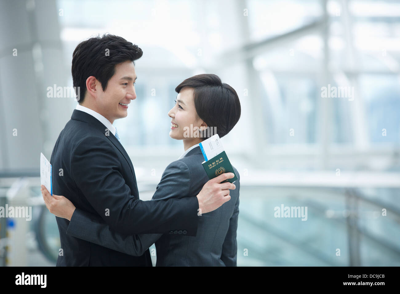 a businesswoman and businessman hugging each other in the airport Stock ...