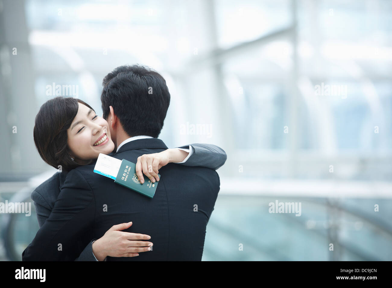 a businesswoman and businessman hugging each other in the airport Stock ...