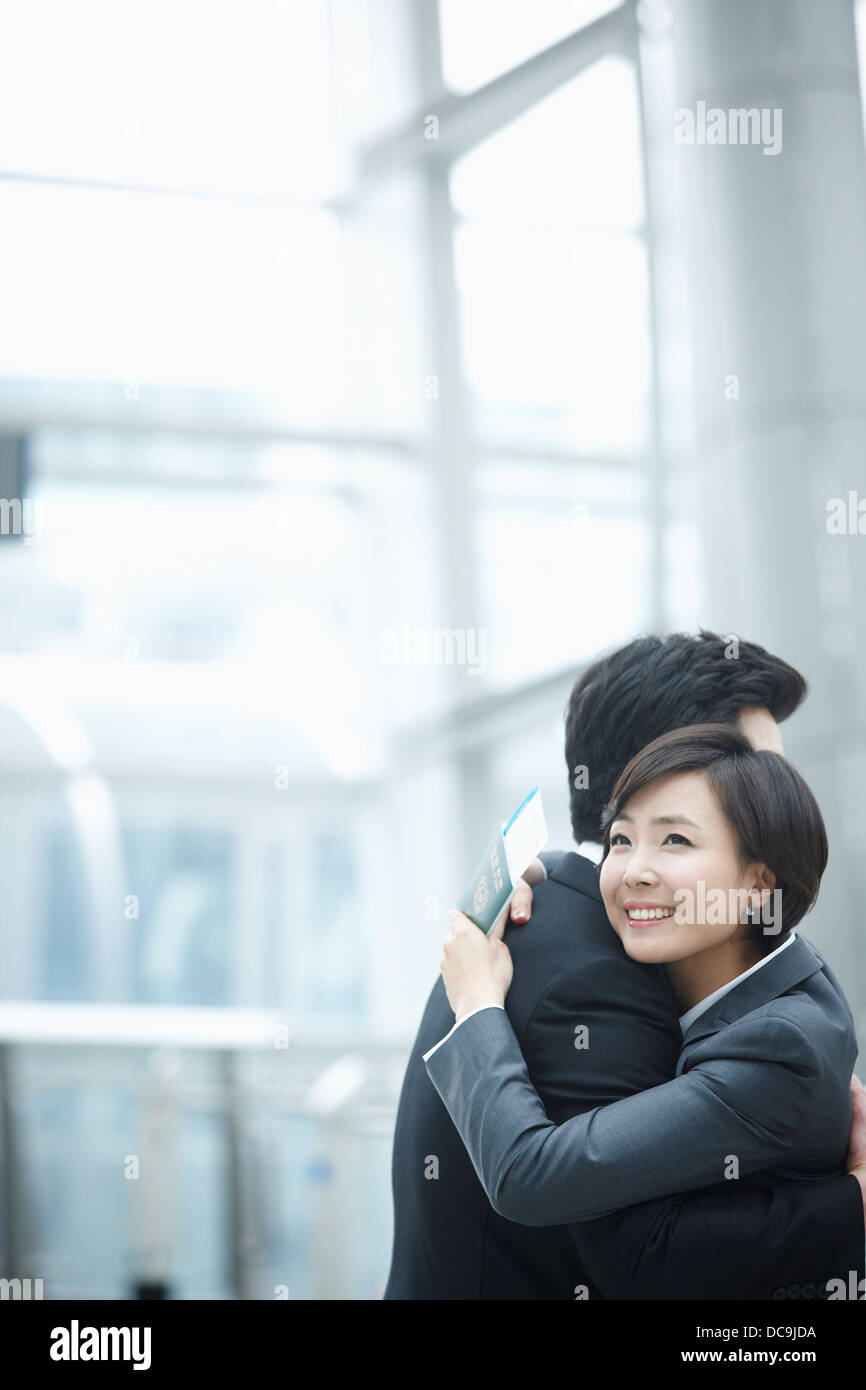 a businesswoman and businessman hugging each other in the airport Stock ...