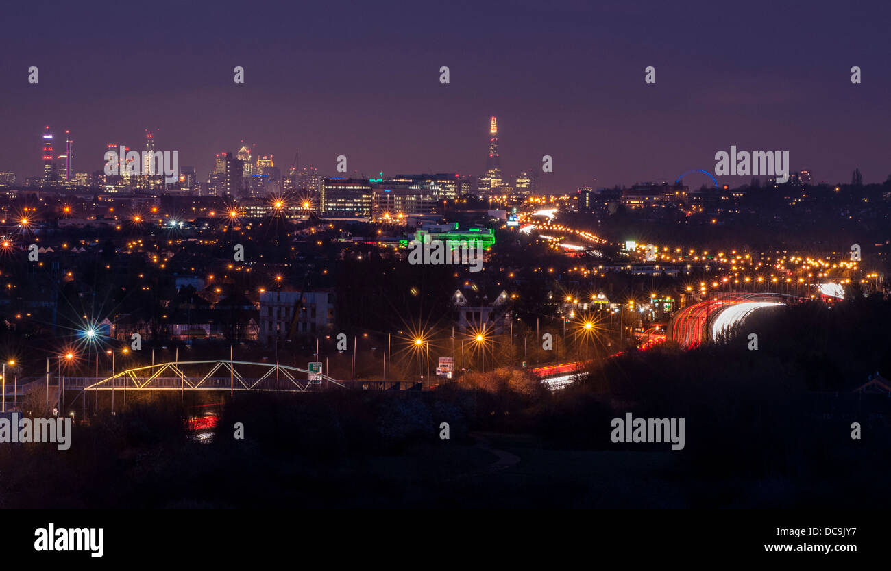 Looking west at the London skyline at night with A40 commuter road busy ...