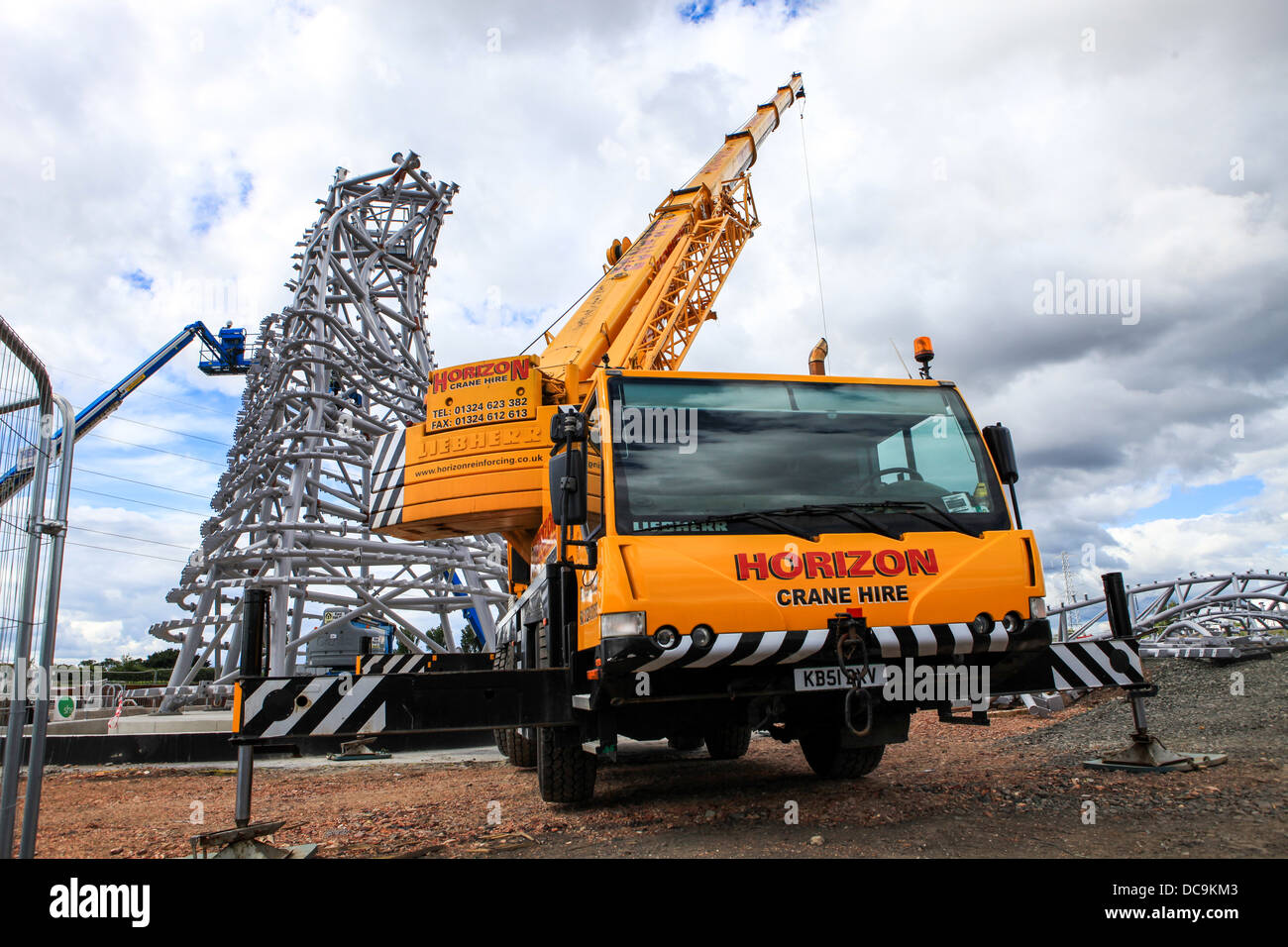 A large mobile crane on a construction site with a part built structure ...