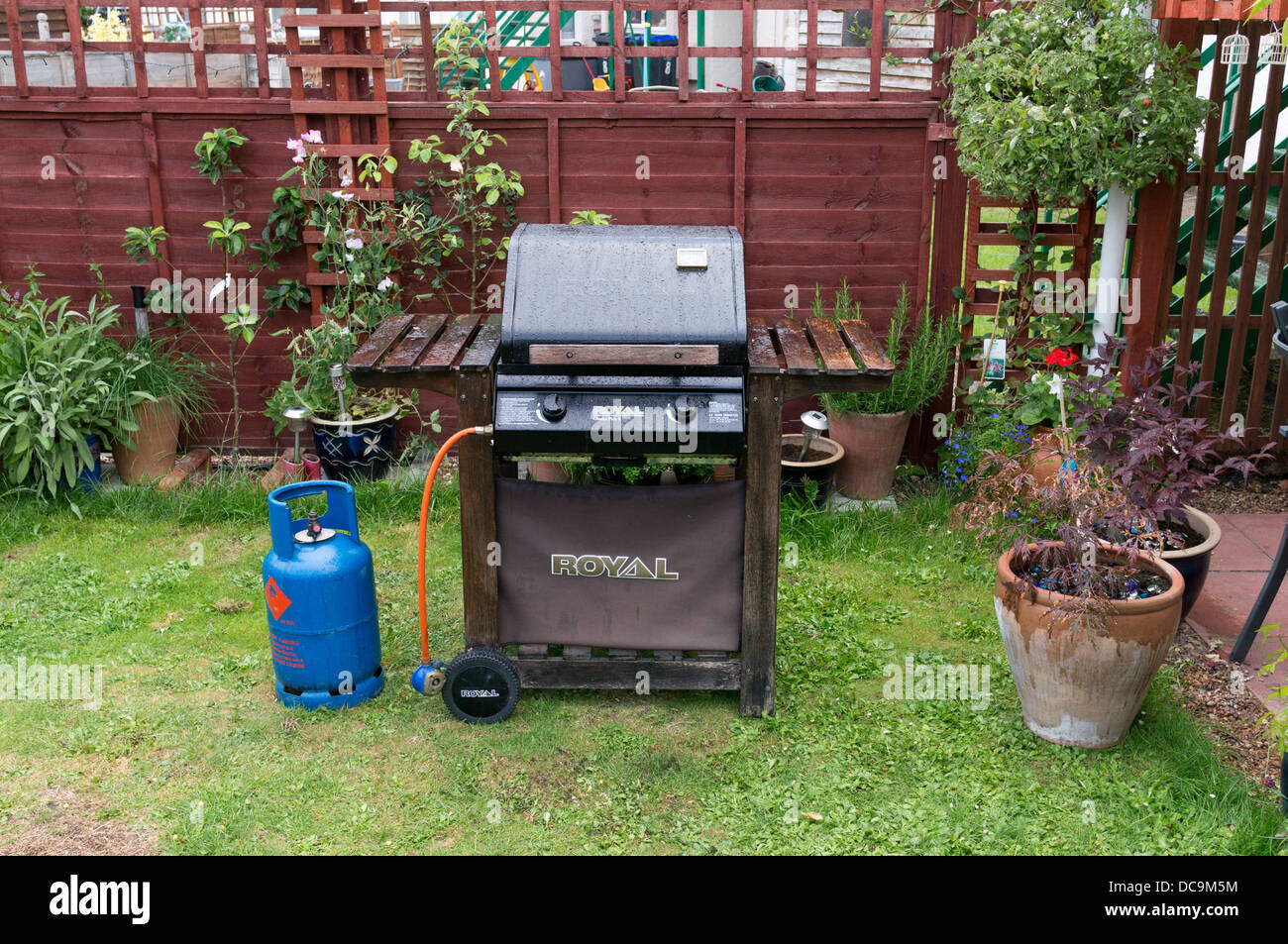 Wet gas fired BBQ in rain in garden Stock Photo - Alamy