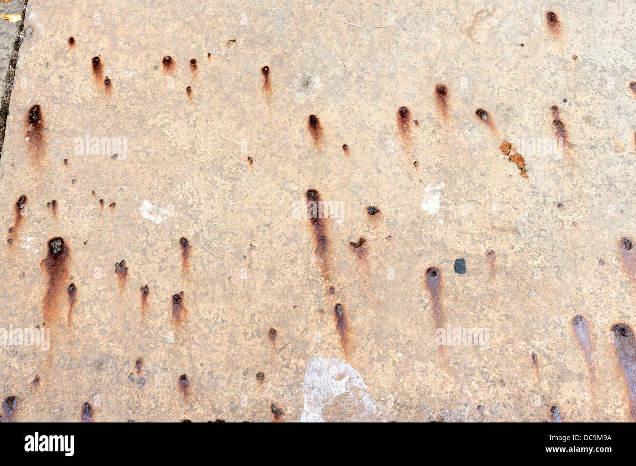 Old paving stone in UK pavement sidewalk with rusting iron oxide ...