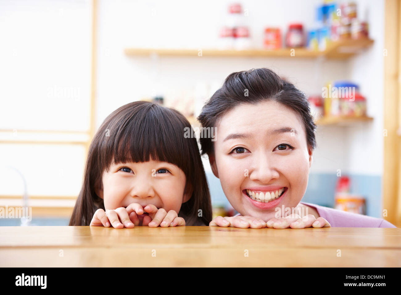 mother and daughter hiding behind table Stock Photo - Alamy