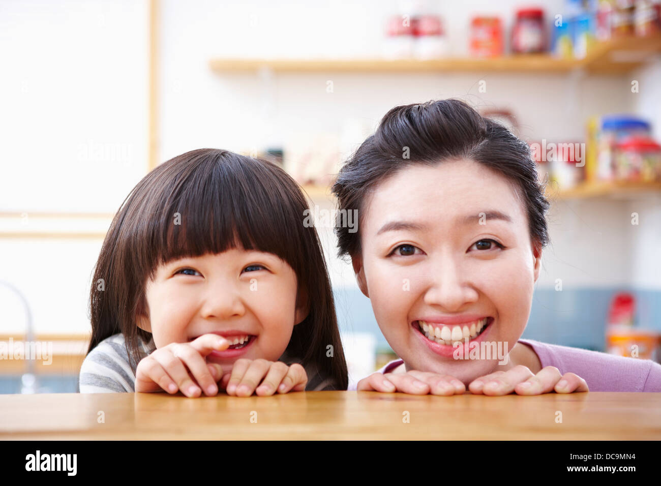 mother and daughter hiding behind table Stock Photo - Alamy