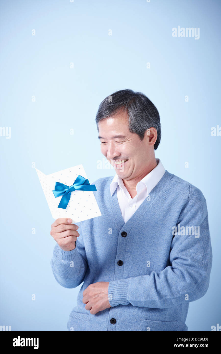 middle aged man reading a card Stock Photo - Alamy