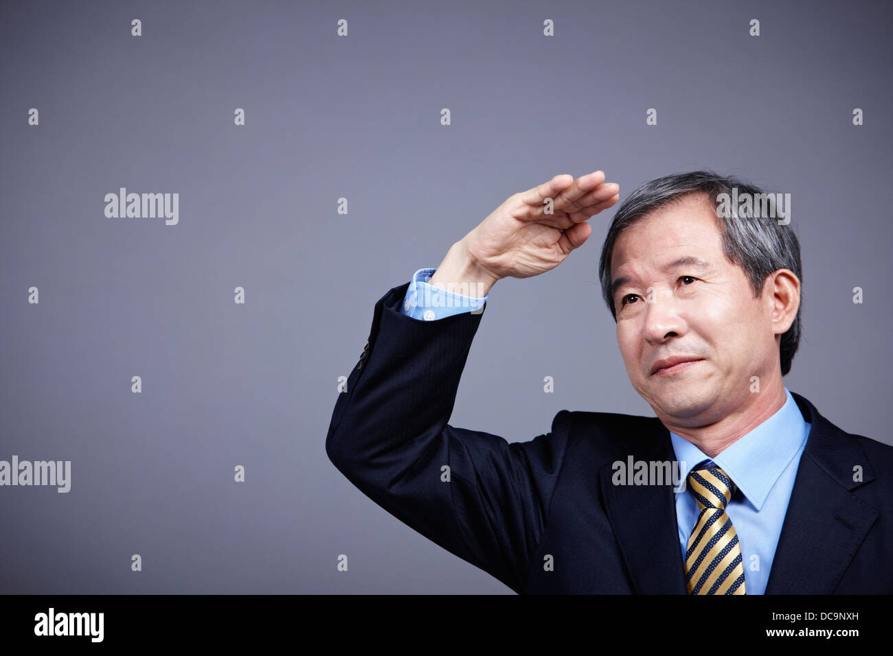 middle aged man in a business suit with salute sign Stock Photo - Alamy