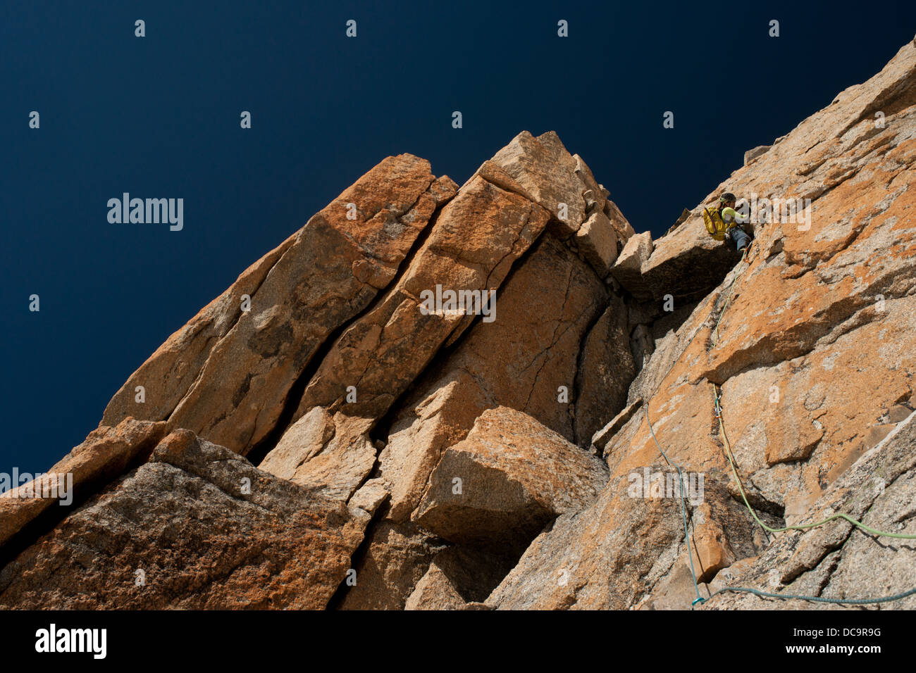 Low view on alpinist leading rock cliff, Freney Pillar of Mont Blanc ...