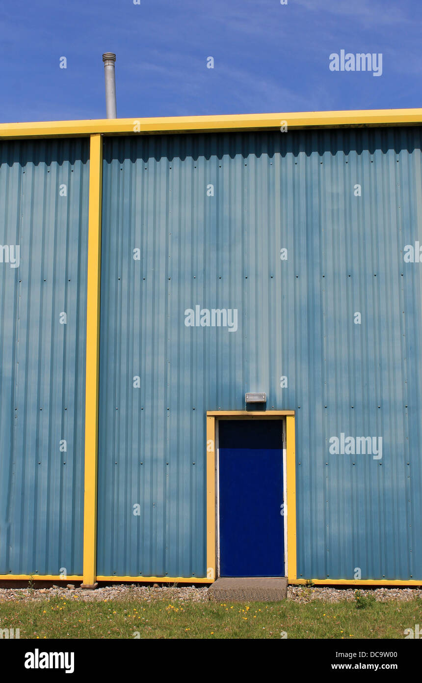 Exterior of blue and yellow modern warehouse building, sky background ...