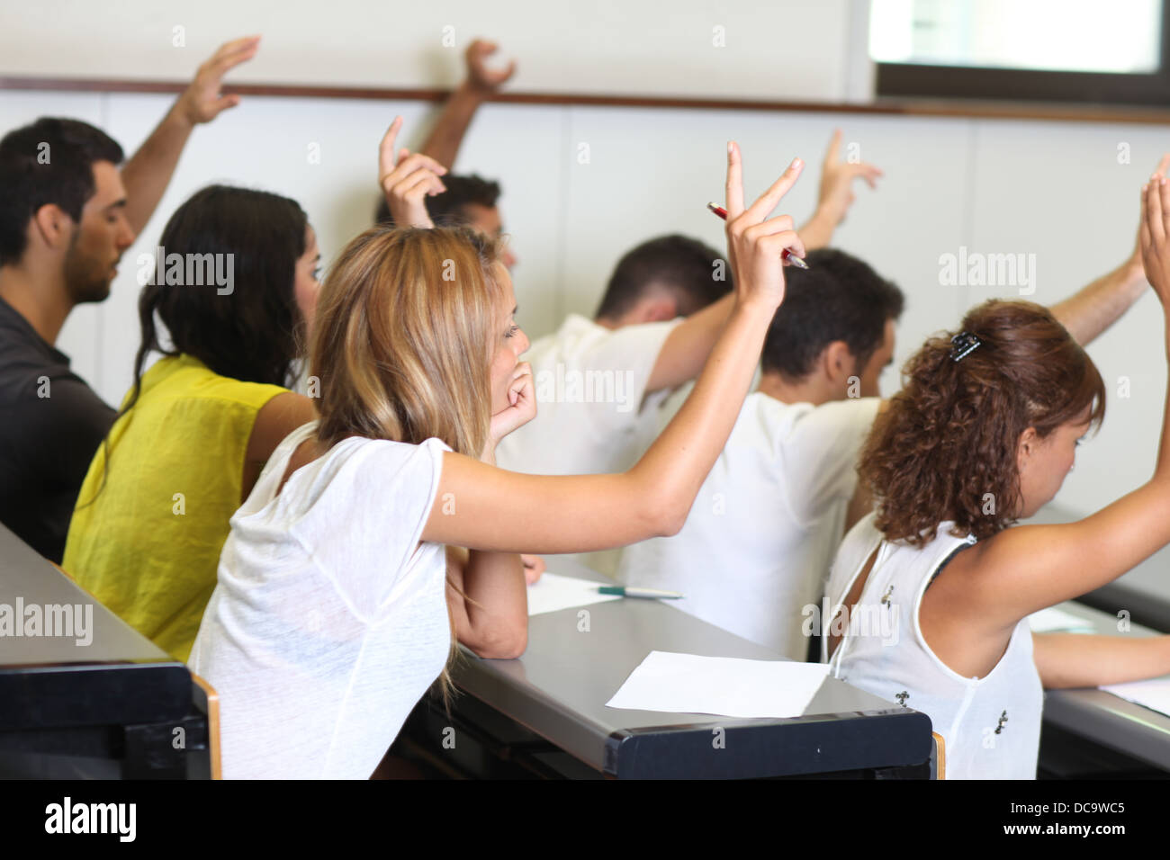 Students put hands up Stock Photo - Alamy