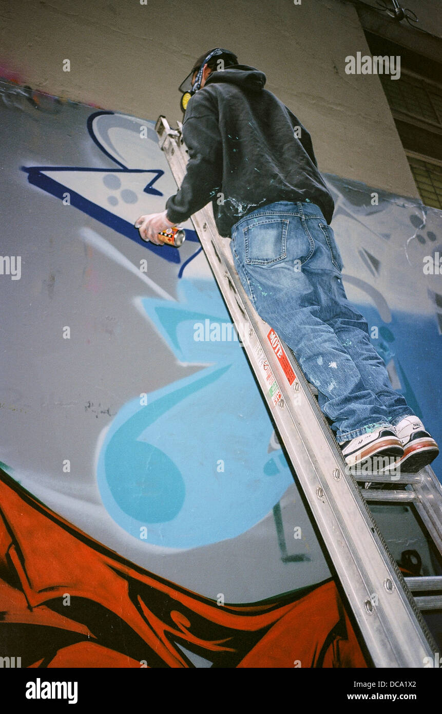 Graffiti artist in Melbourne up a ladder Stock Photo - Alamy