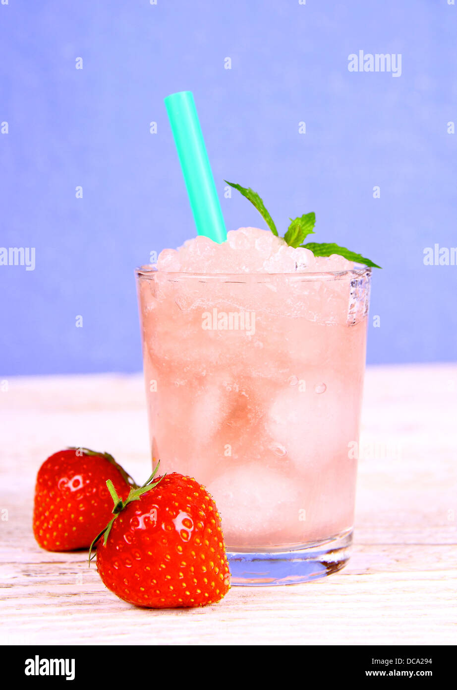 Strawberry slush in glass with straw on blue background, close up Stock ...