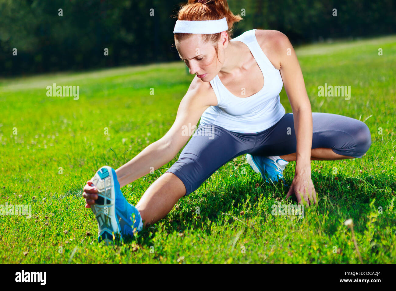 Young girl stretches before exercise in park Stock Photo - Alamy